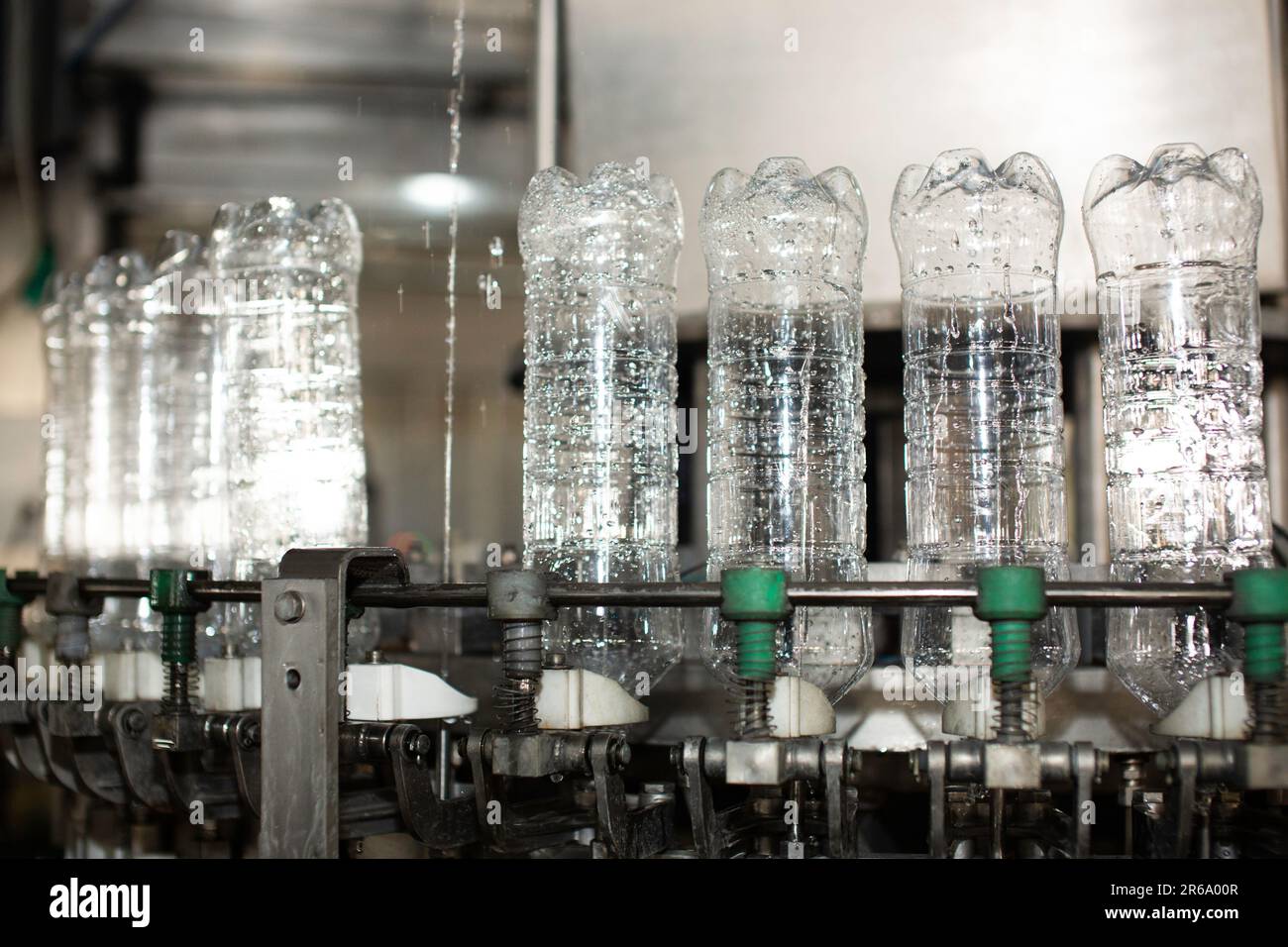 A row of plastic bottles being filled with liquid Stock Photo - Alamy