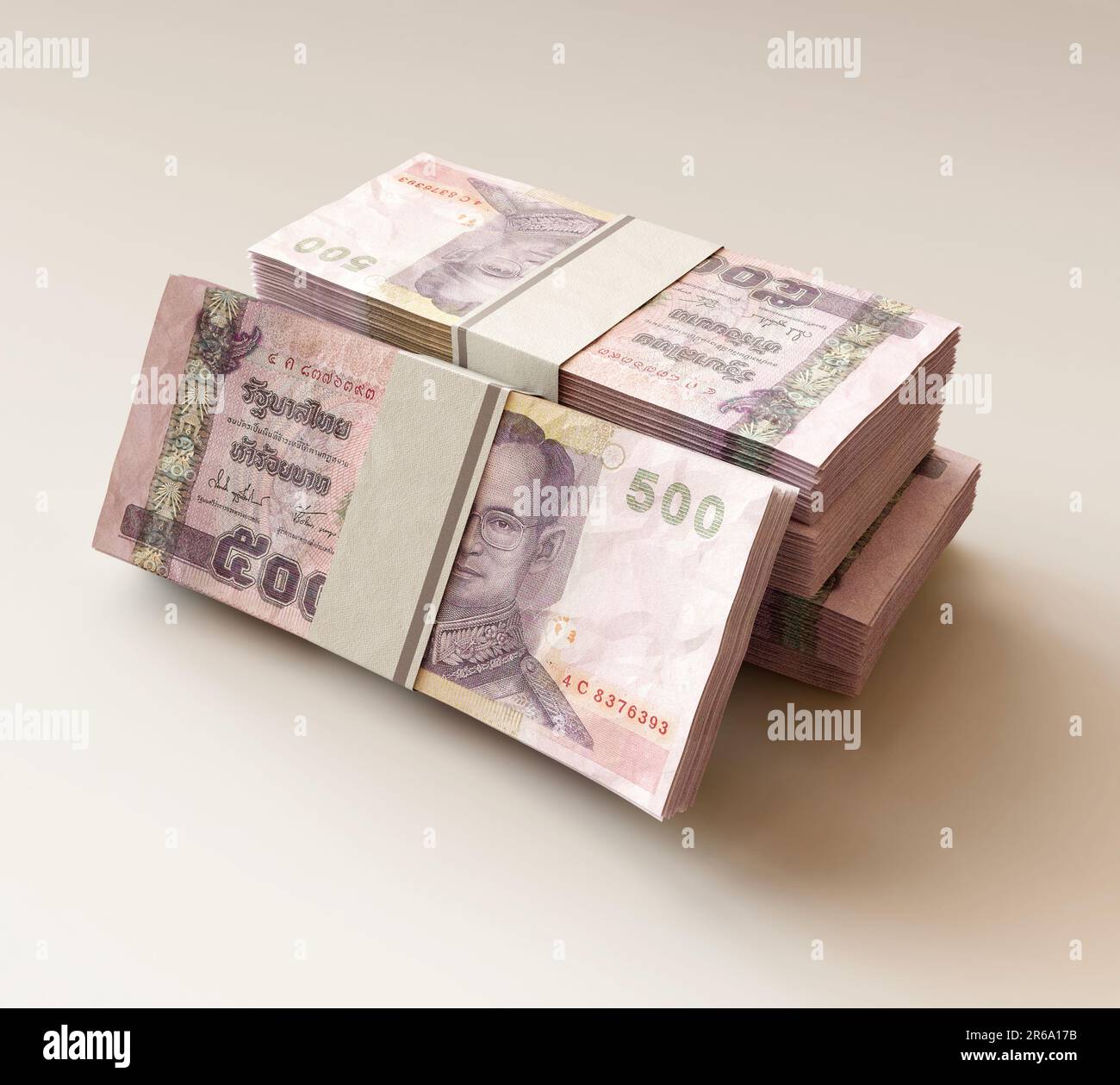 A stack of bundled thai bhat banknotes on an isolated light background ...