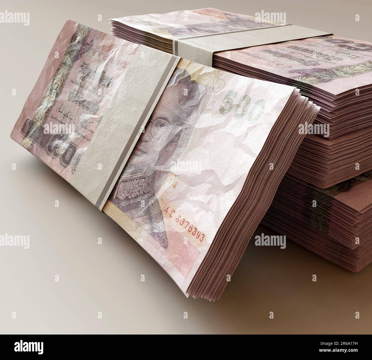 A stack of bundled thai bhat banknotes on an isolated light background ...