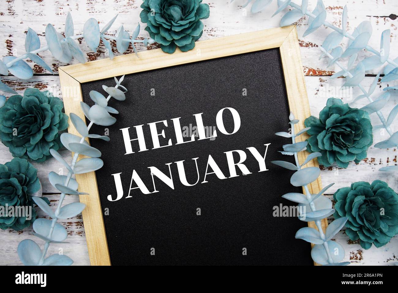 Hello January typography text and flower dcoration on blackboard ...
