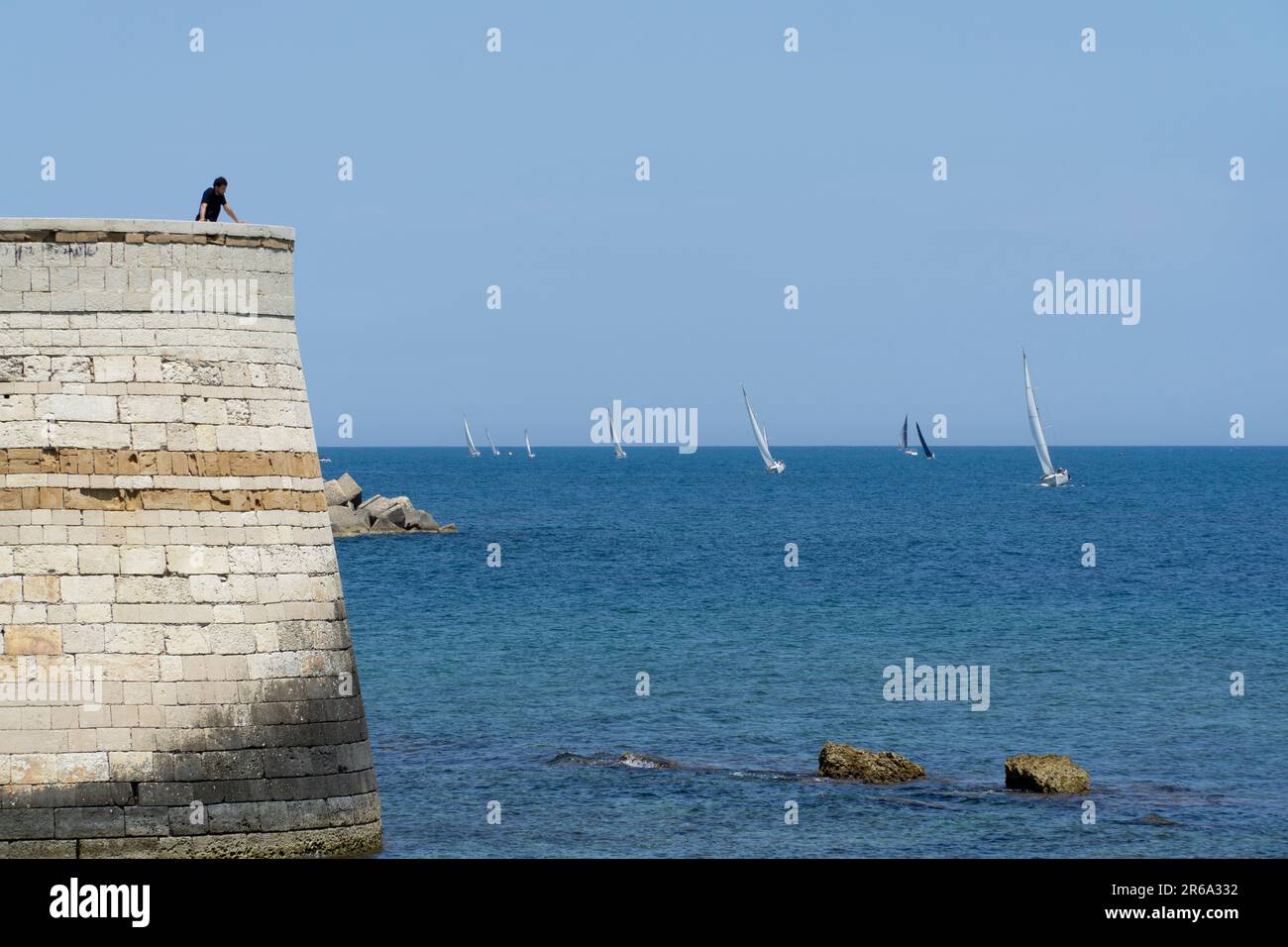 Turret fortification in ortigia island with man looking out to sea ...