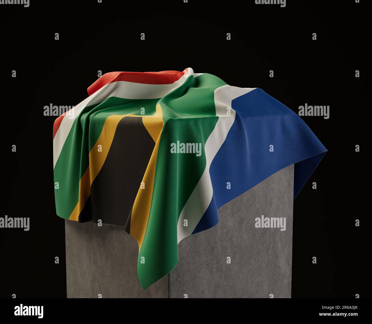A South Africa flag draped over a stone plinth on an isolated dark ...
