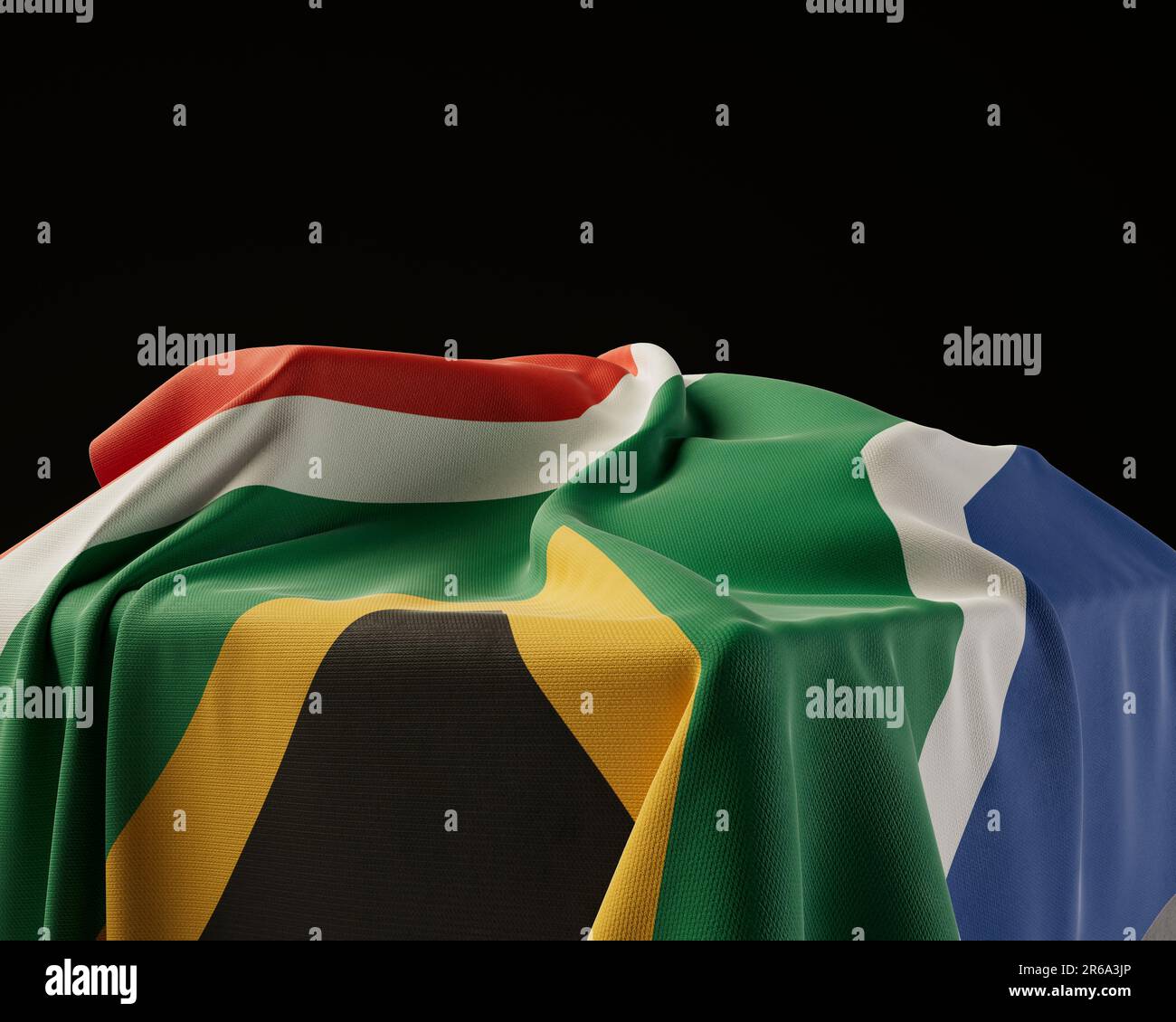 A South Africa flag draped over a stone plinth on an isolated dark ...