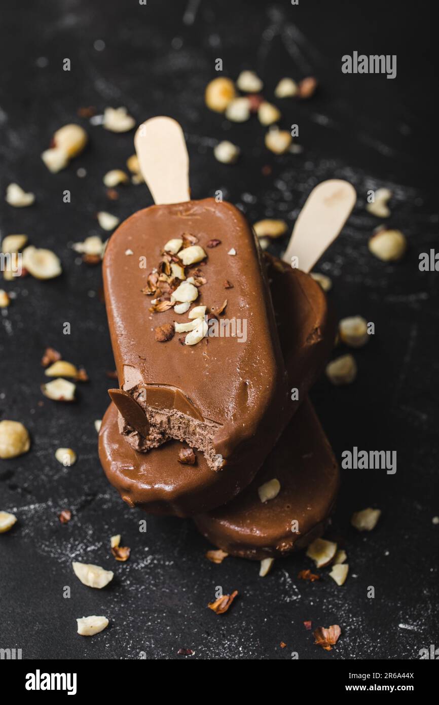 Milk chocolate popsicles with hazelnuts. Close-up. Ice cream popsicles ...