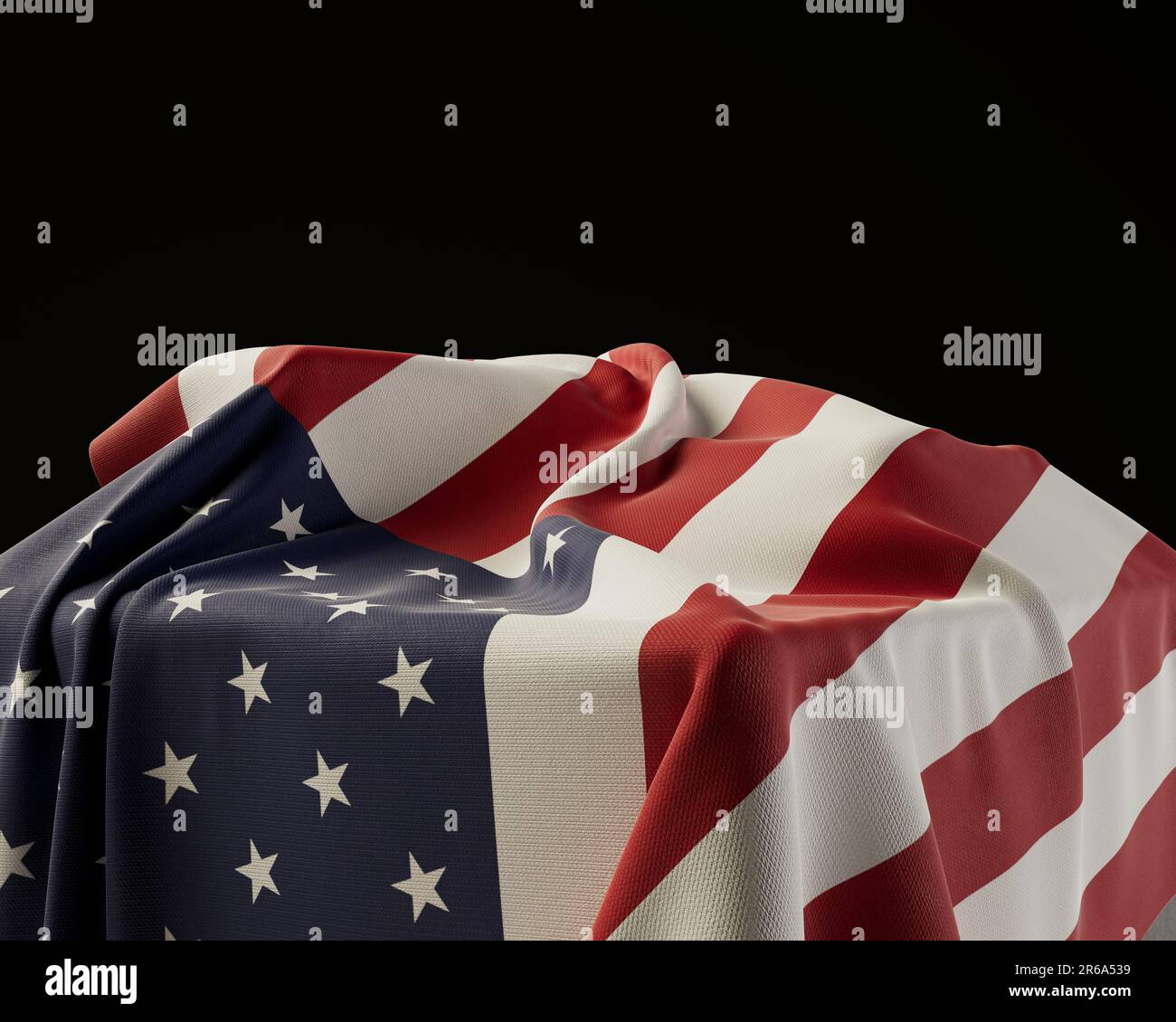 An american flag draped over a stone plinth on an isolated dark studio ...