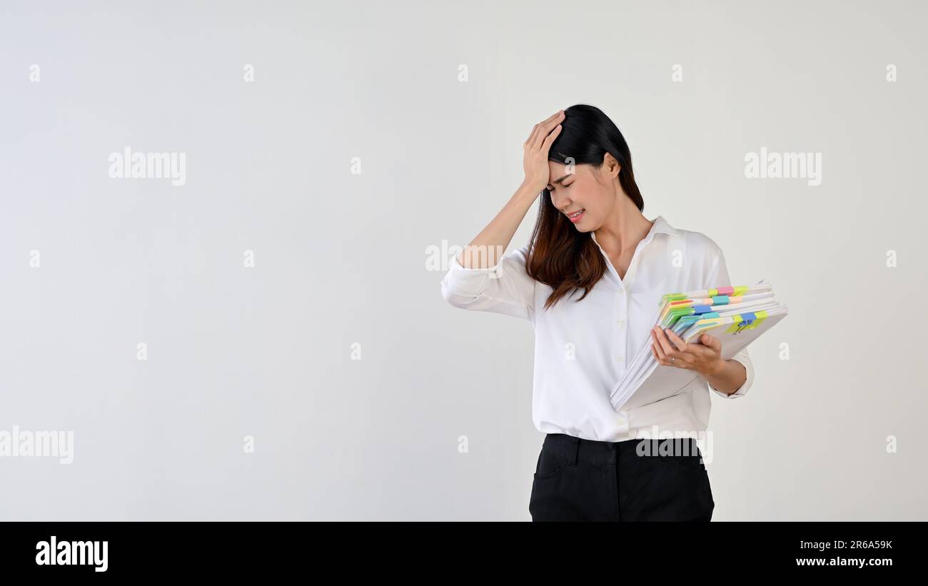 A sad, upset and crying young Asian female employee holds a pile of ...