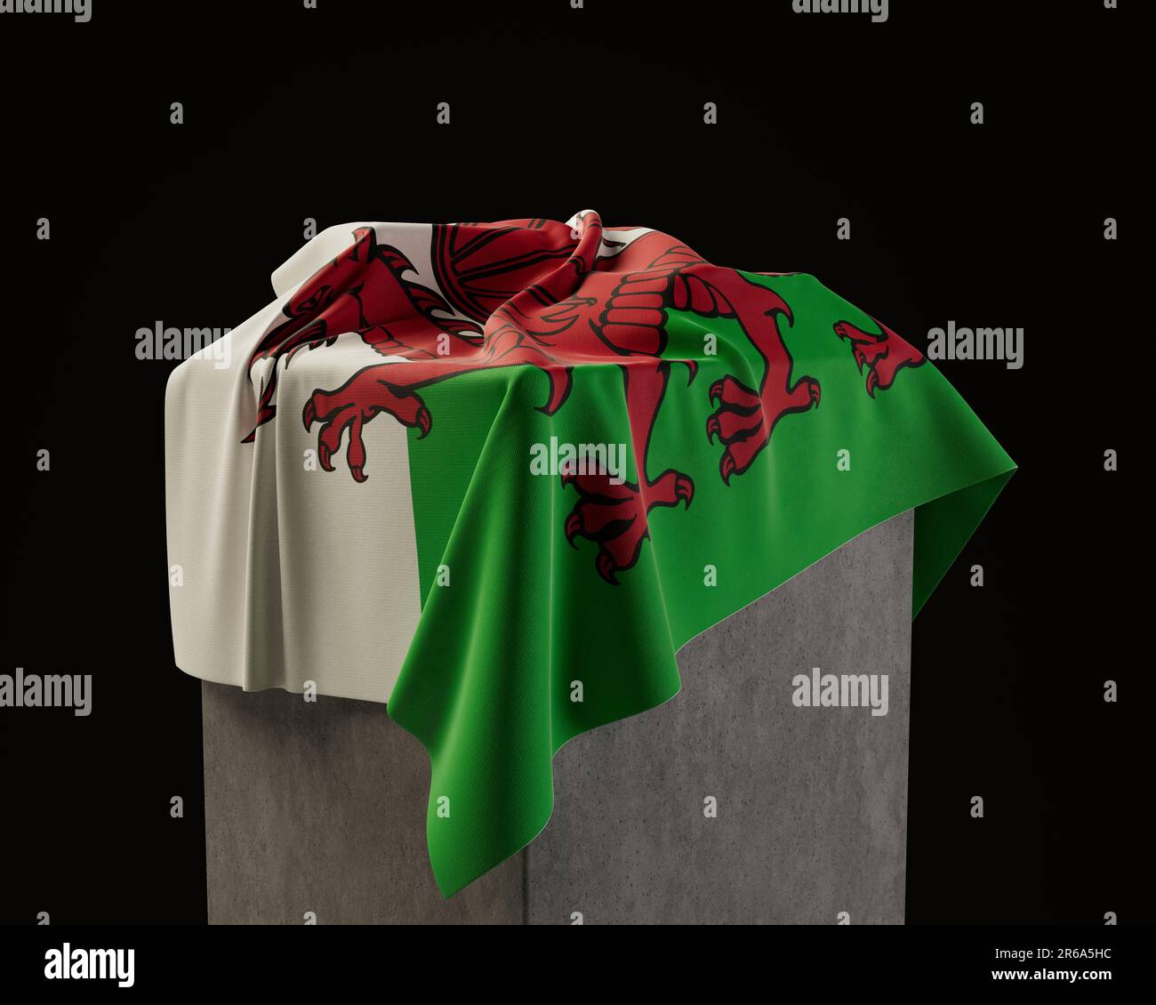 A wales flag draped over a stone plinth on an isolated dark studio ...