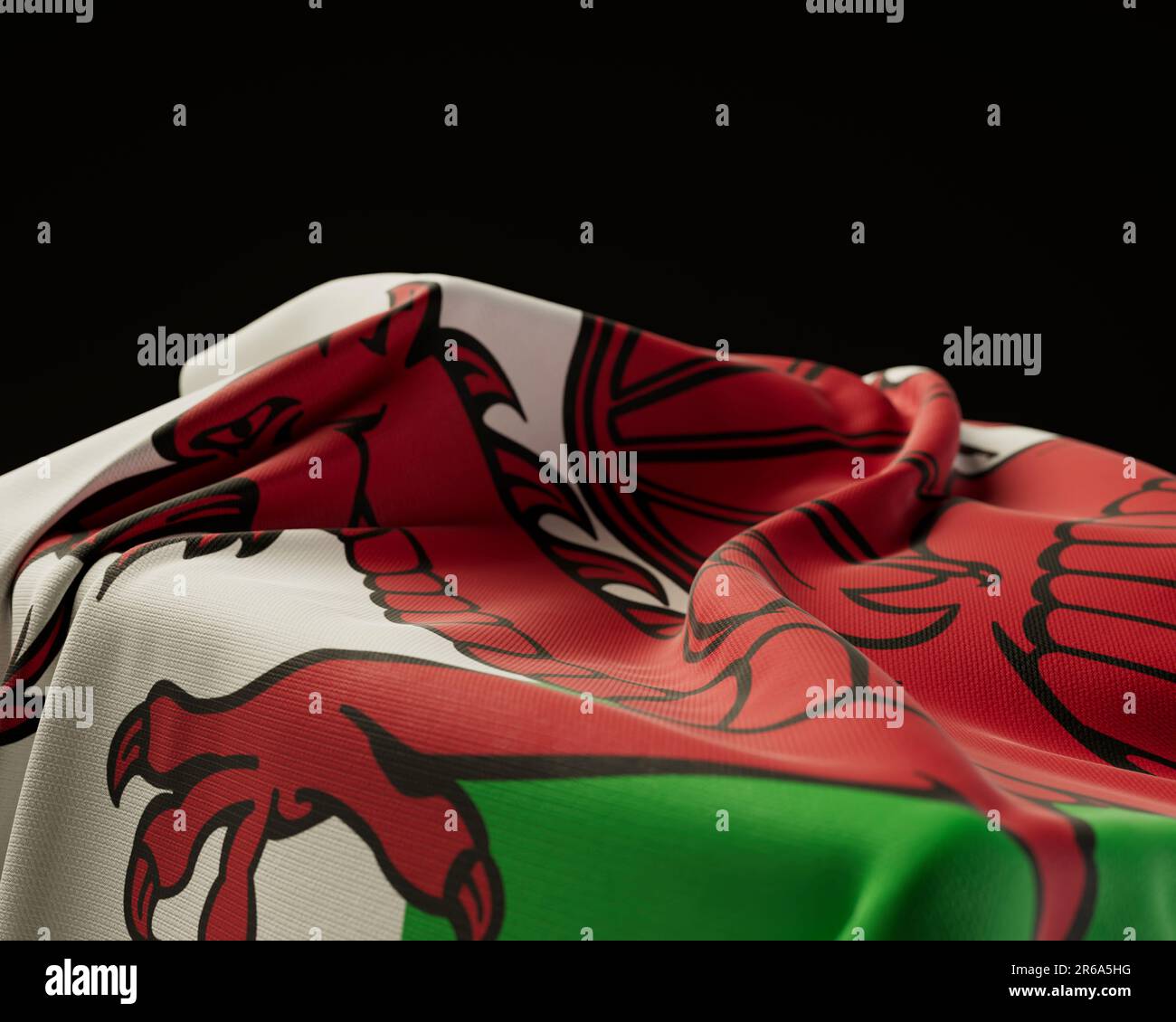 A wales flag draped over a stone plinth on an isolated dark studio ...