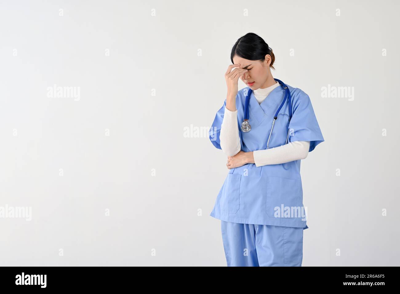 A stressed and overworked young Asian female doctor or medical worker ...