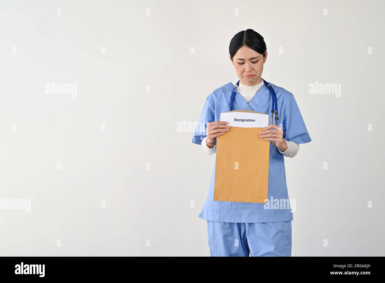 A sad and upset young Asian female doctor or medical worker in scrubs ...