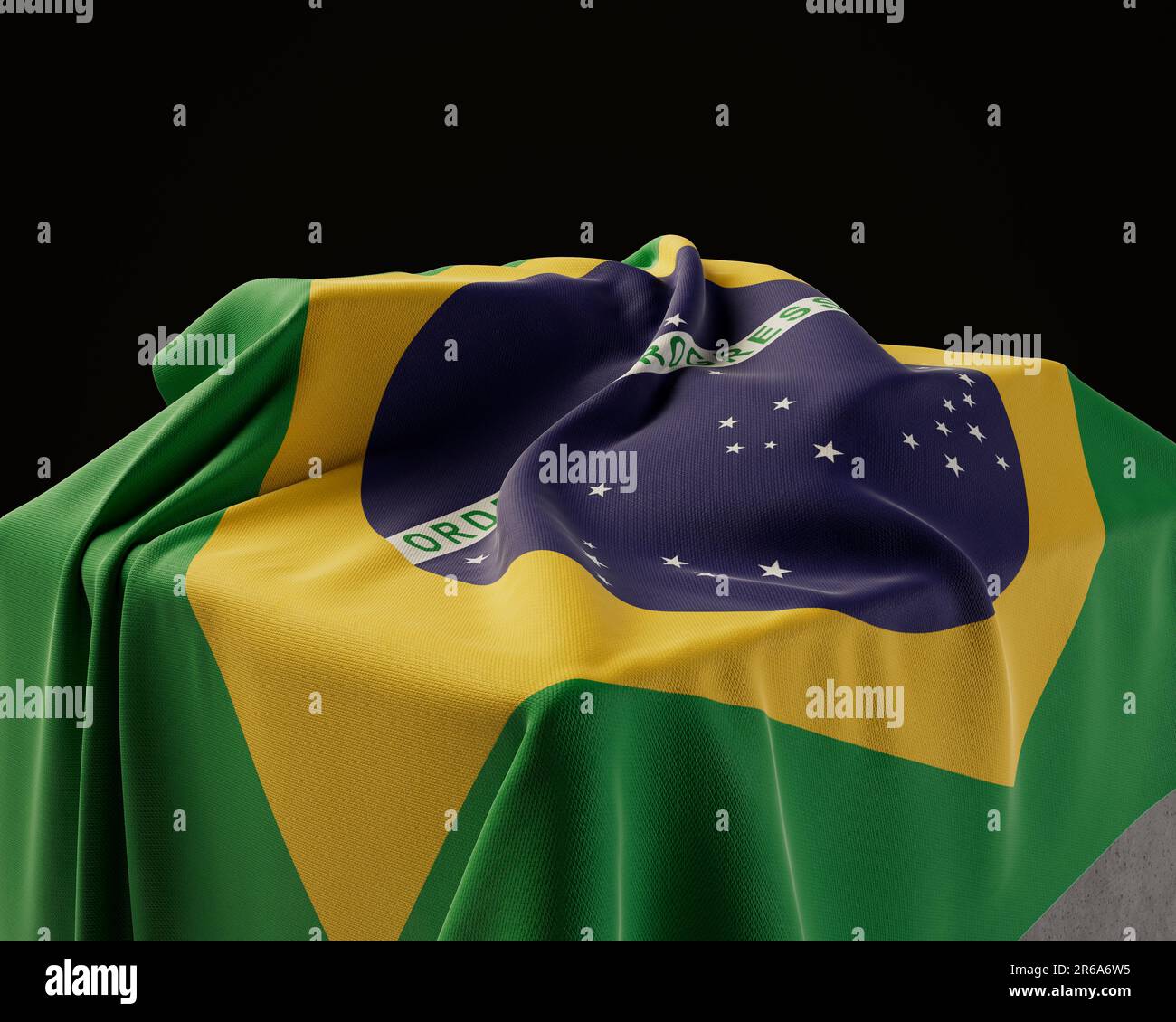 A brazil flag draped over a stone plinth on an isolated dark studio ...