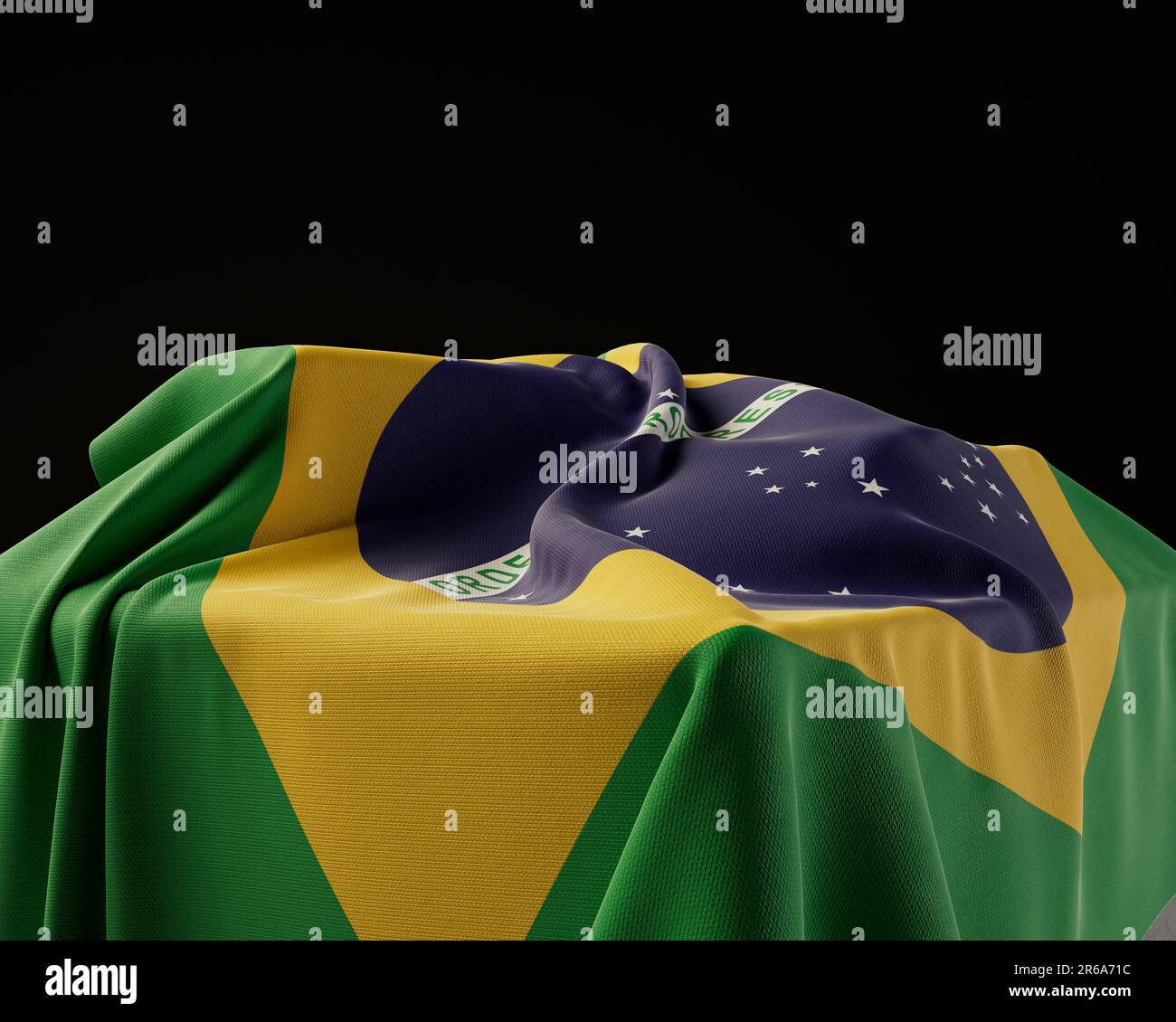 A brazil flag draped over a stone plinth on an isolated dark studio ...
