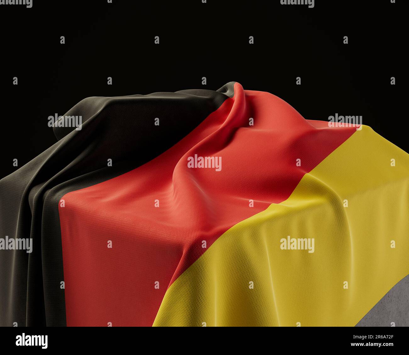 A germany flag draped over a stone plinth on an isolated dark studio ...