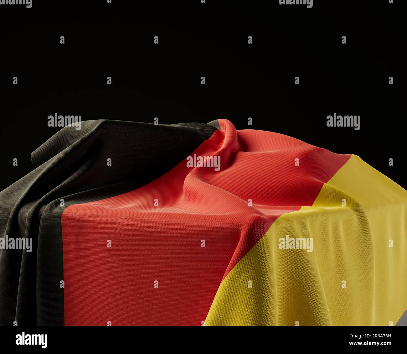 A germany flag draped over a stone plinth on an isolated dark studio ...