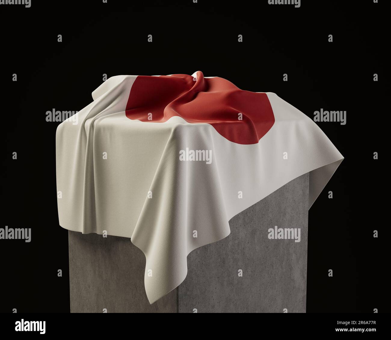 A japan flag draped over a stone plinth on an isolated dark studio ...