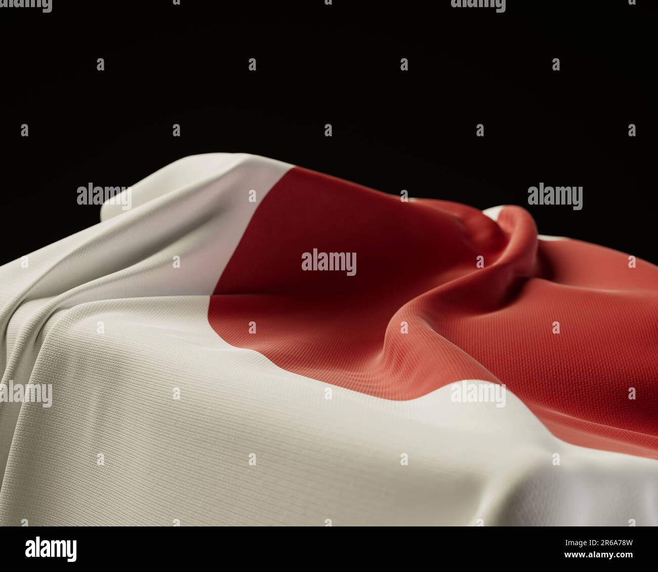 A japan flag draped over a stone plinth on an isolated dark studio ...