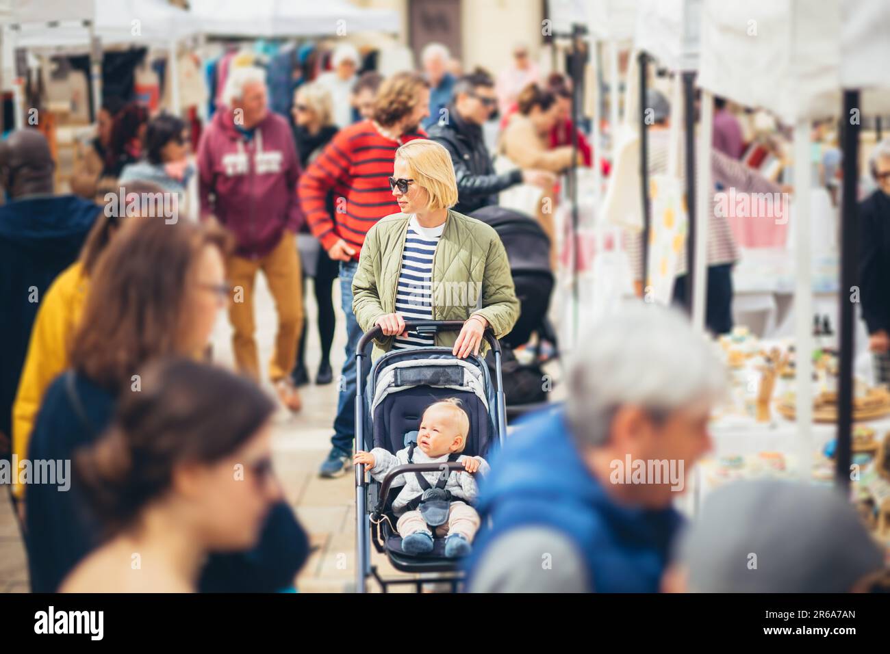 Mother waling and pushing his infant baby boy child in stroller in ...