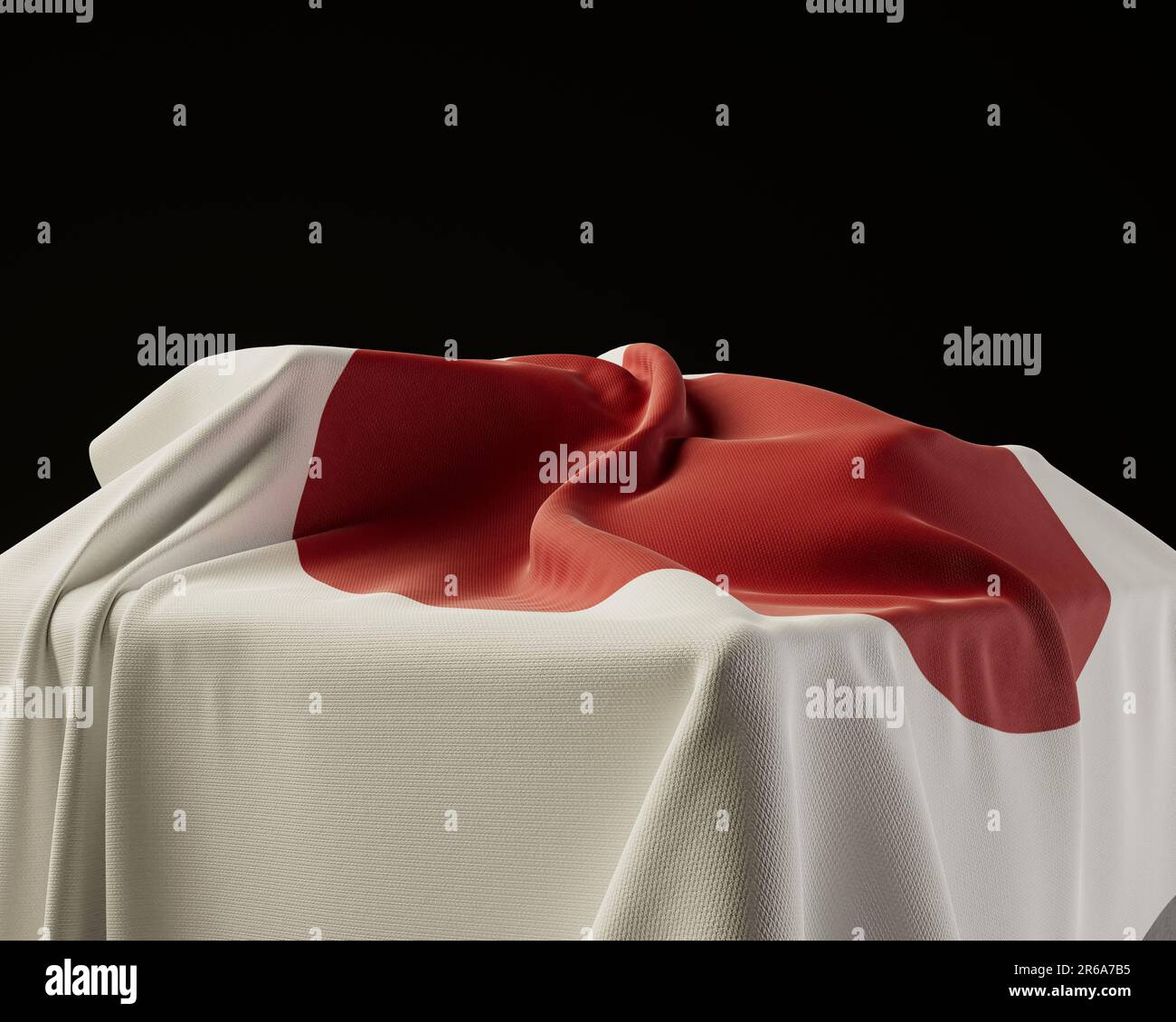 A japan flag draped over a stone plinth on an isolated dark studio ...