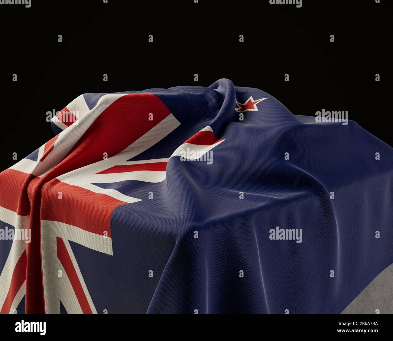 A new zealand flag draped over a stone plinth on an isolated dark ...