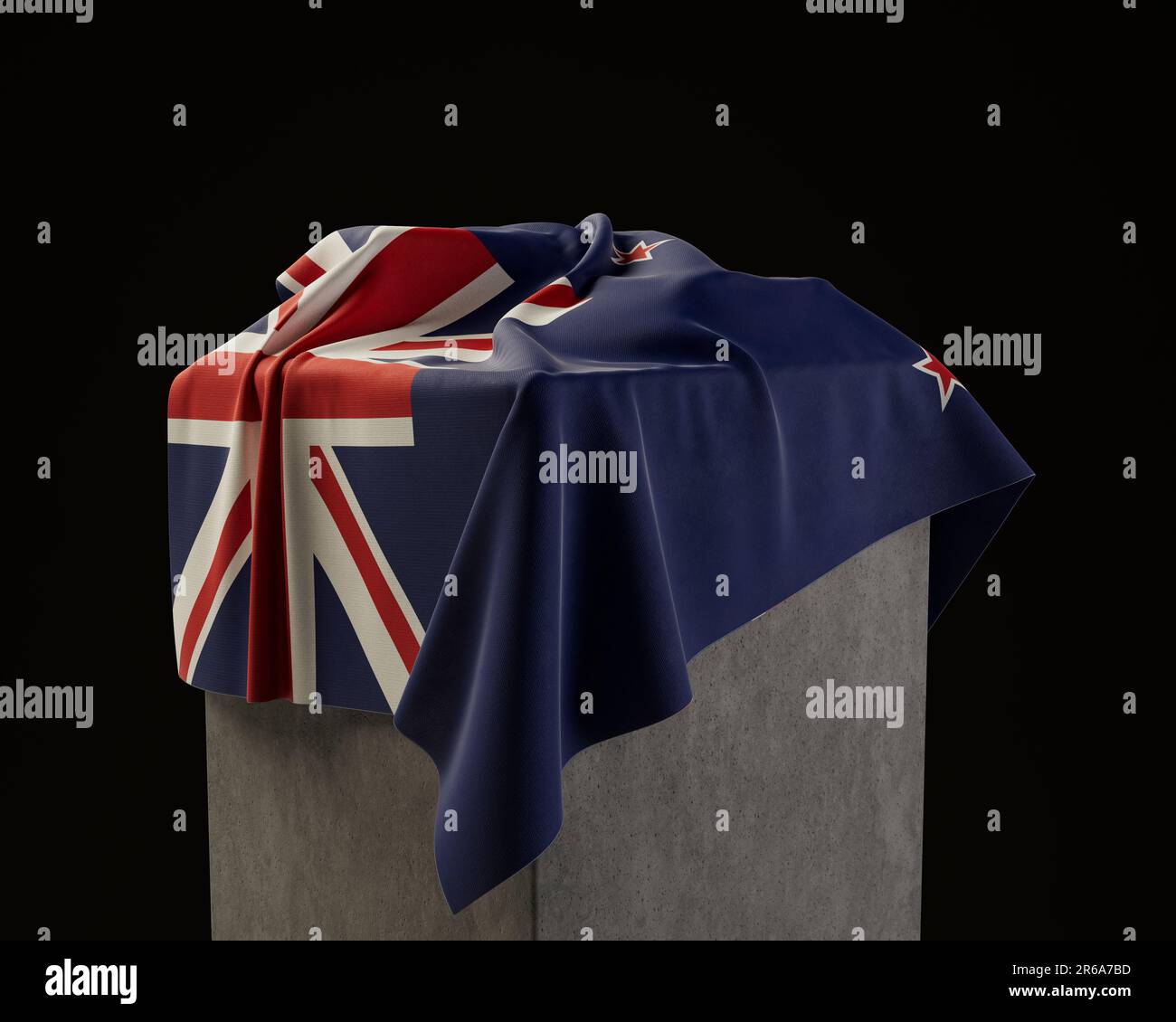 A new zealand flag draped over a stone plinth on an isolated dark ...