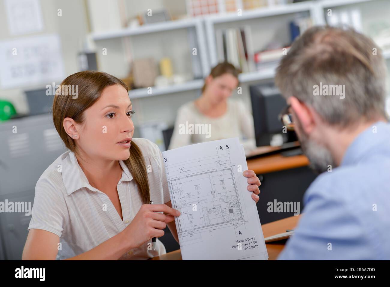 Showing plans to her client Stock Photo - Alamy