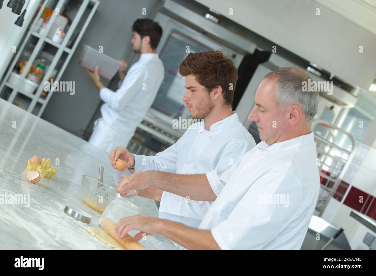 baker with students in kitchen making pastries Stock Photo - Alamy