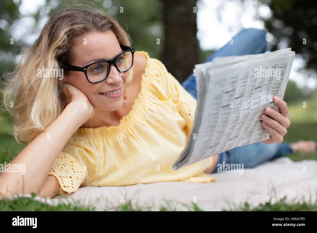 happy young woman reading newspaper Stock Photo - Alamy