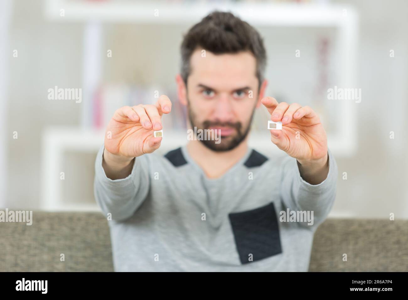 portrait of man holding sim card in each hand Stock Photo - Alamy