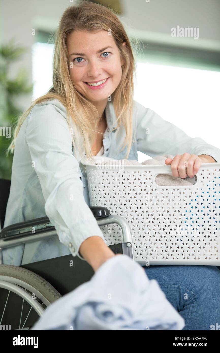 happy housewife in wheelchair in laundry room Stock Photo - Alamy