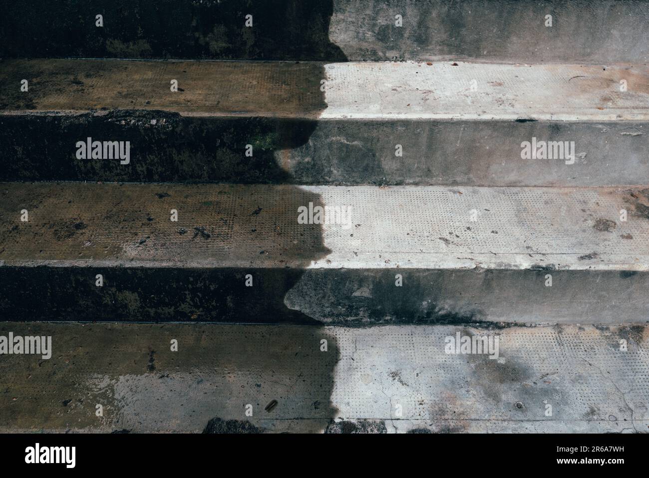 An aged staircase, featuring a cement base, as it ascends into the ...