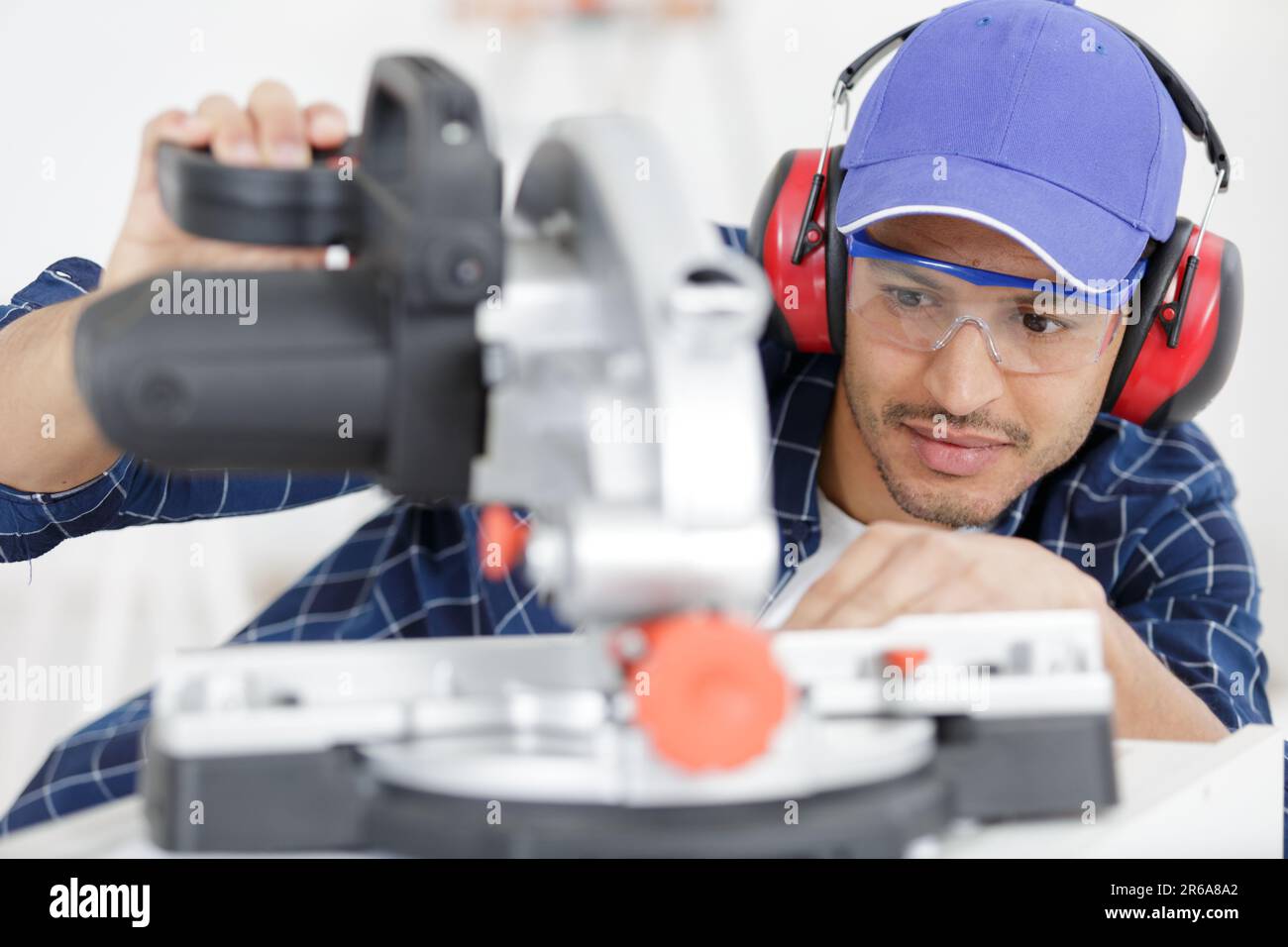 man using circular saw at workshop wearing ear safety Stock Photo - Alamy