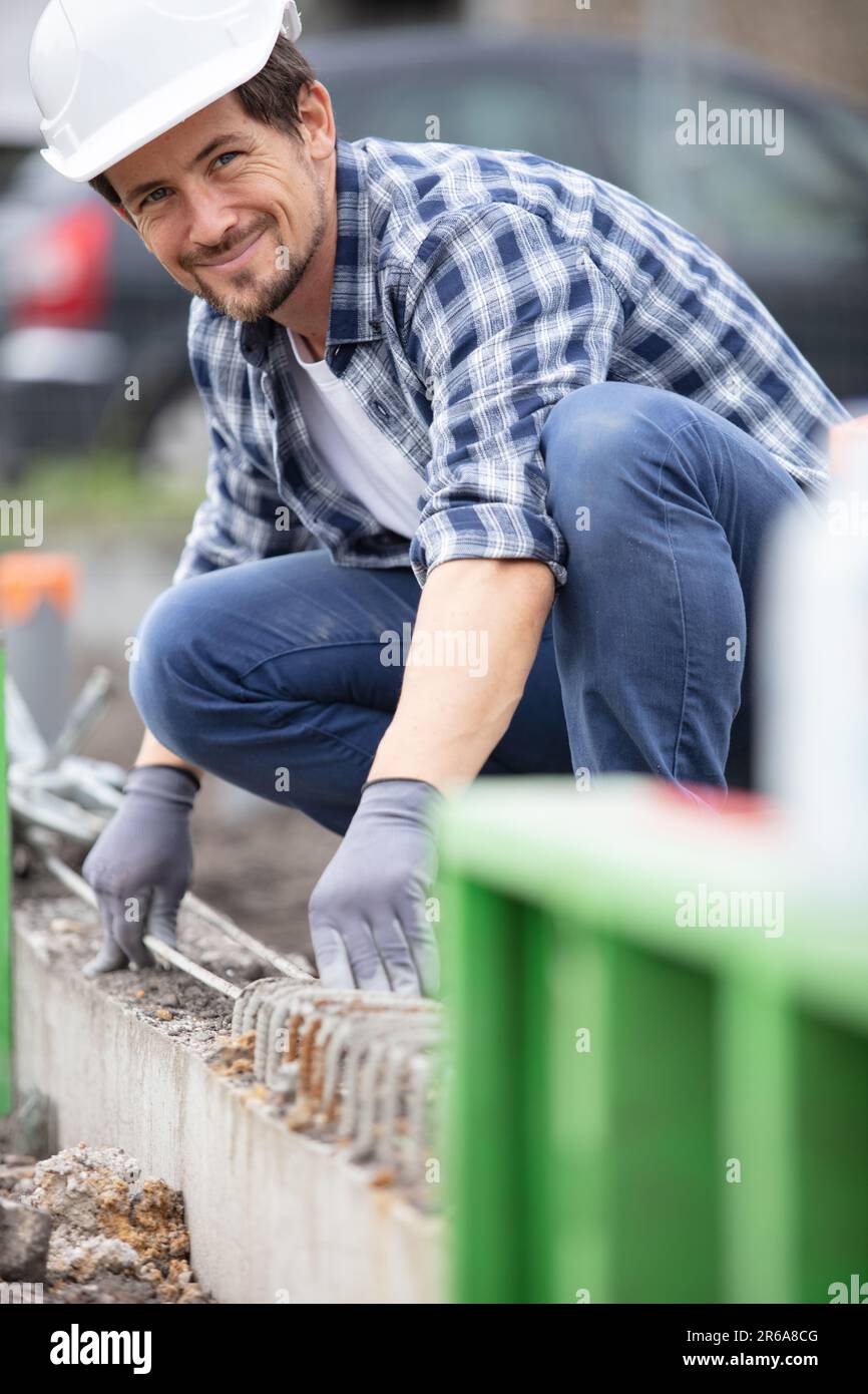 handsome construction worker laying foundations Stock Photo - Alamy