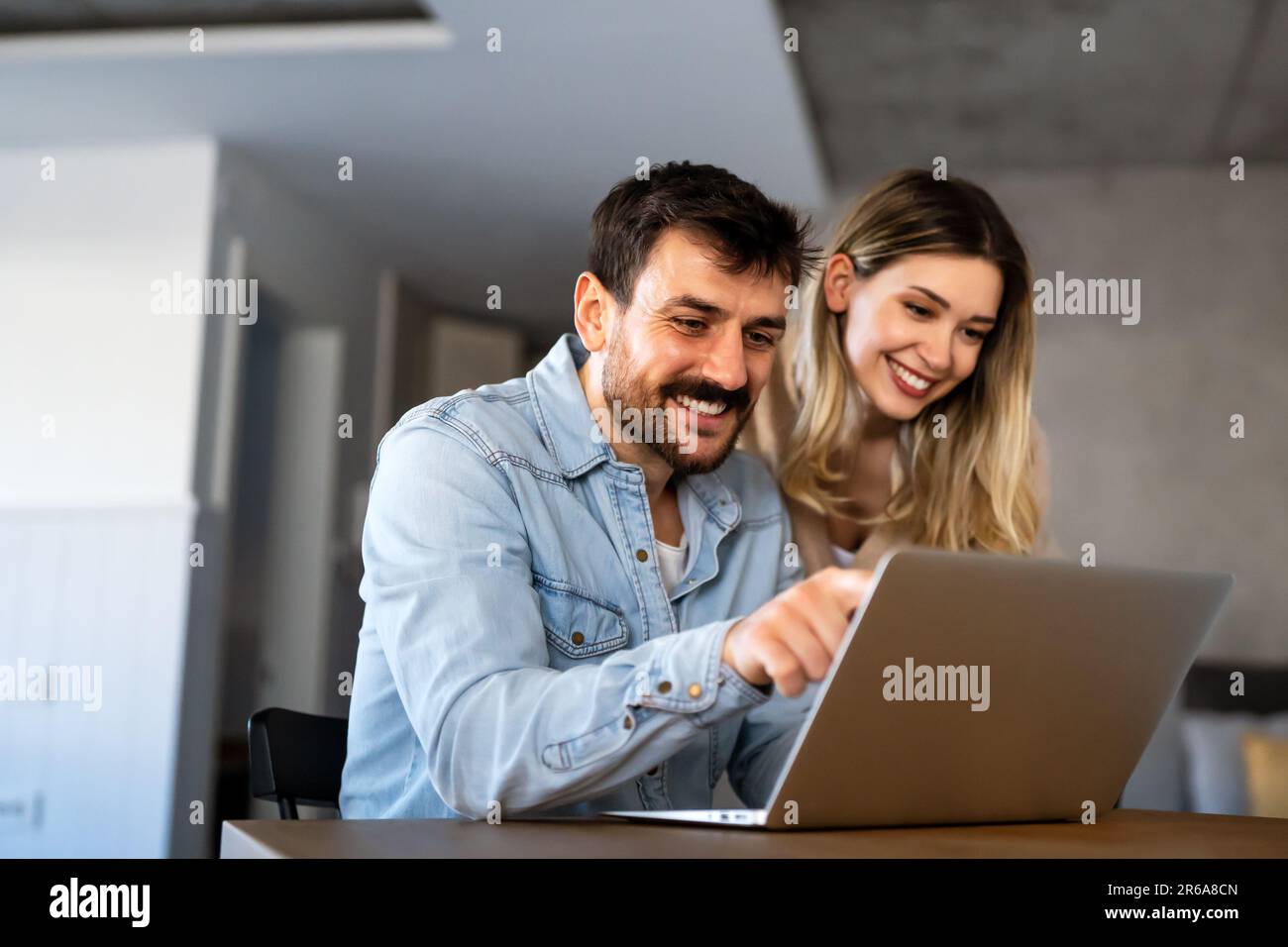 Multiethnic colleagues discussing project while working with laptop in ...