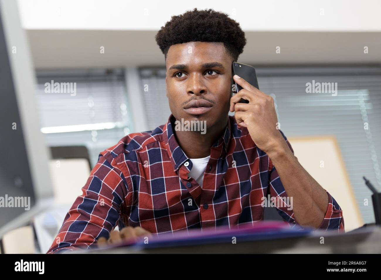 consultant sat at desk having conversation on smartphone Stock Photo ...