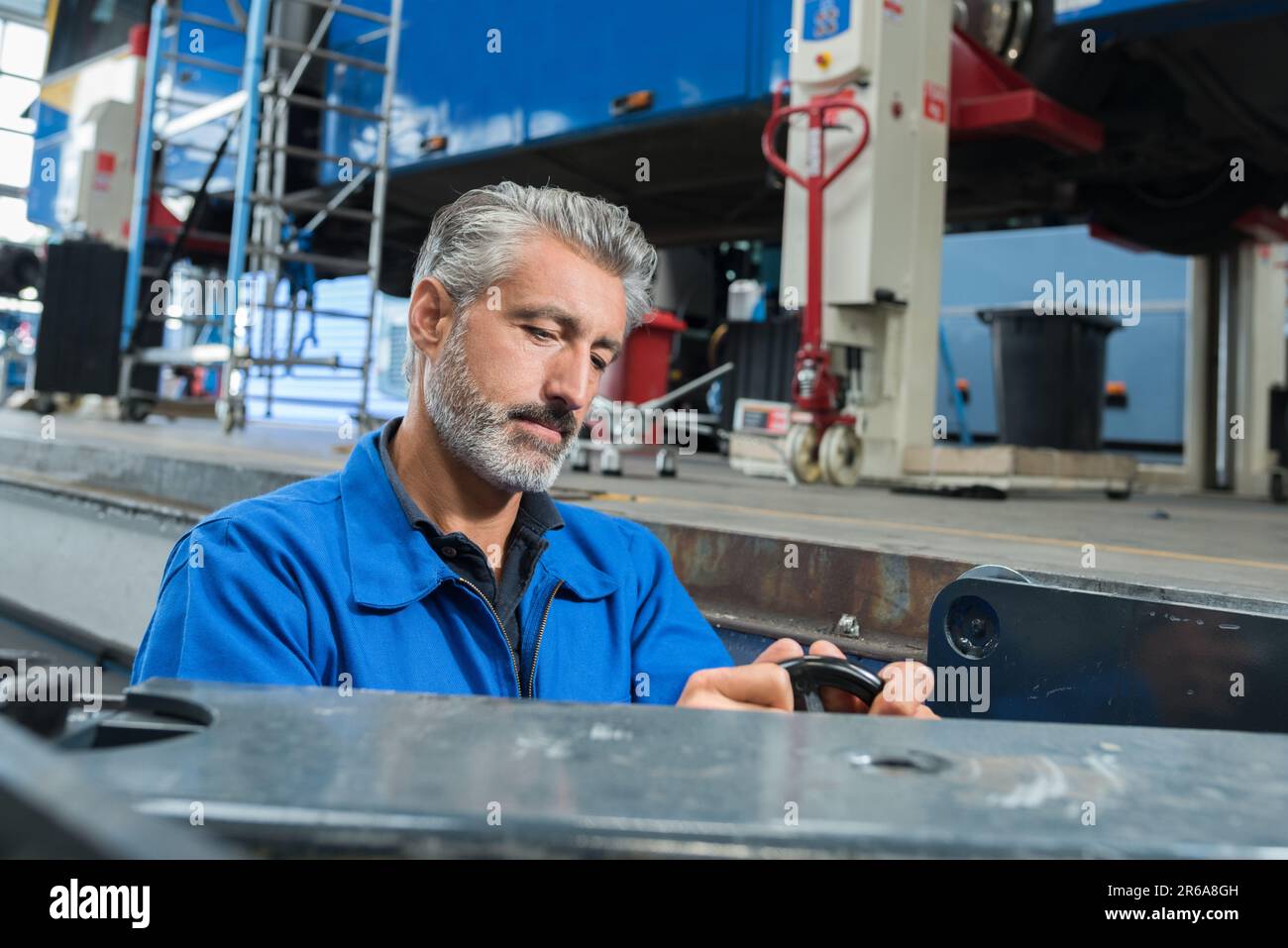 attractive mechanic wearing overalls working alone Stock Photo - Alamy