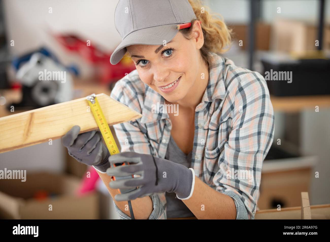female carpenter showing measurement of piece of wood Stock Photo - Alamy