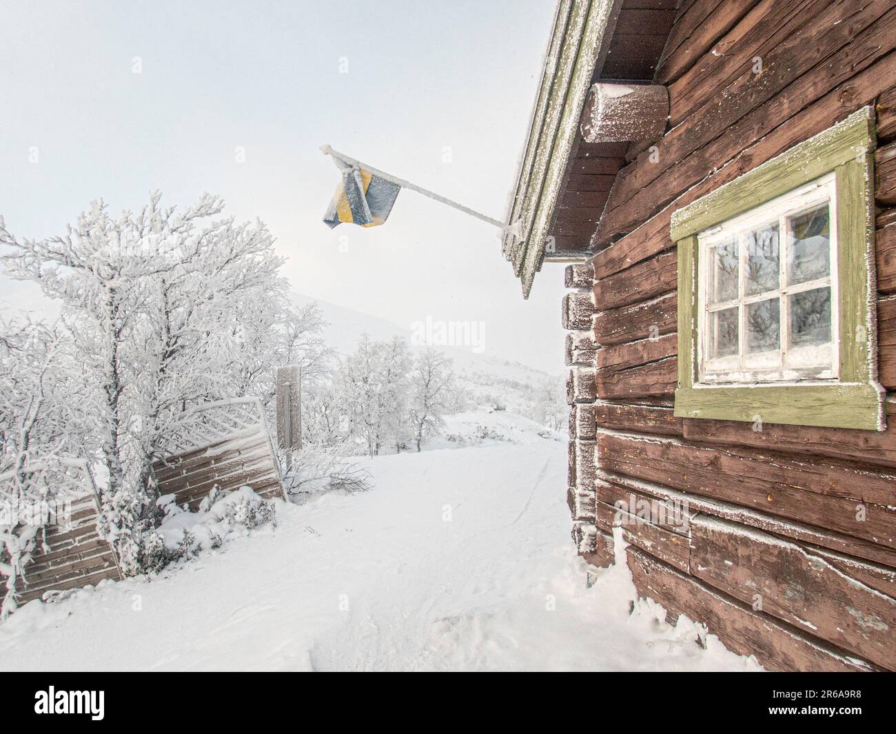 A wintery scene of a charming, cozy log cabin nestled in the middle of ...