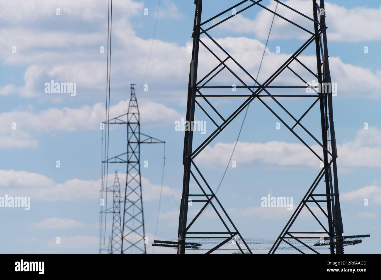 High voltage electricity pylons in a landscape background with cloudy ...