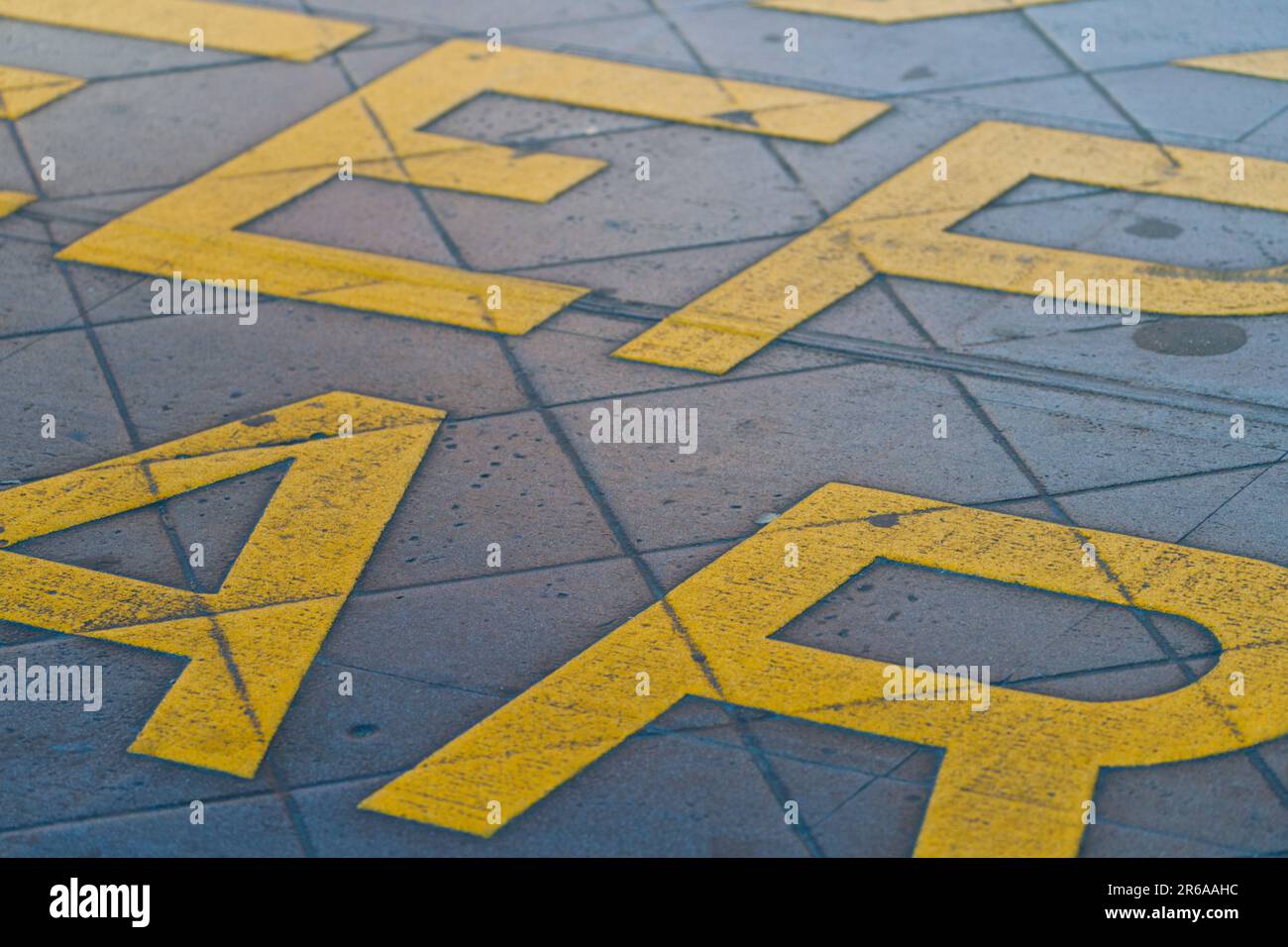Keep clear sign showing yellow graphic letters on road surface ...