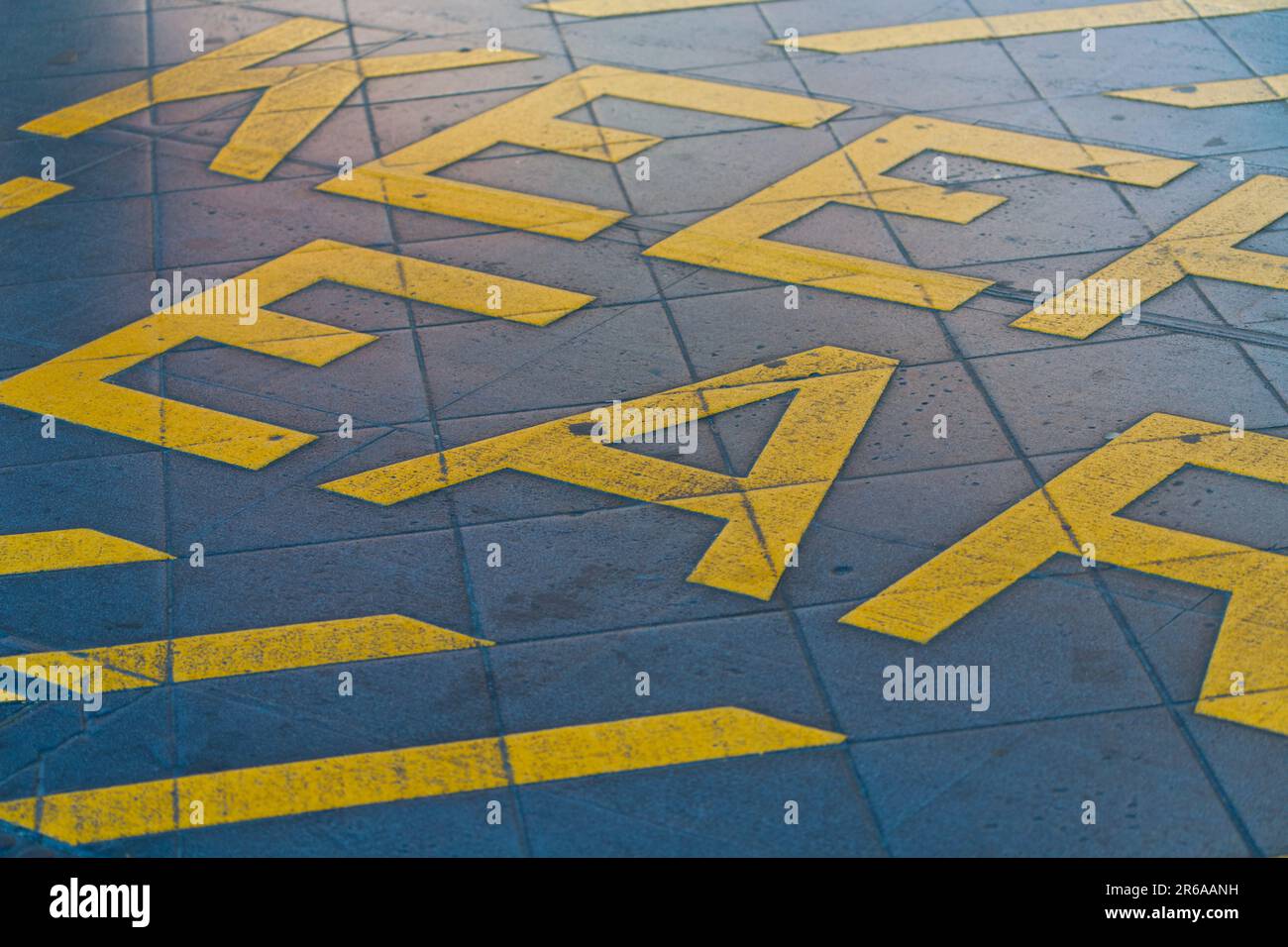 Keep clear sign showing yellow graphic letters on road surface ...
