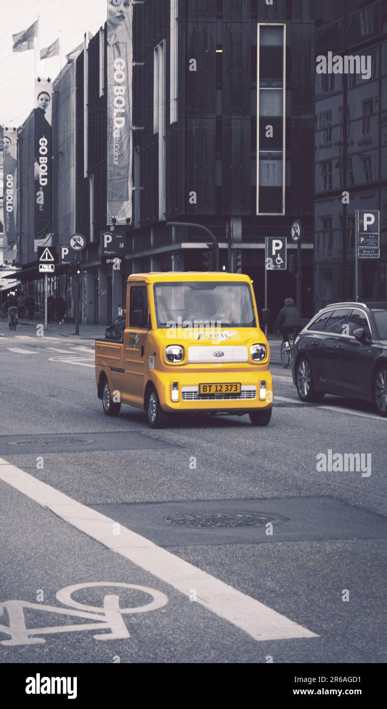yellow car driving down a street Stock Photo - Alamy