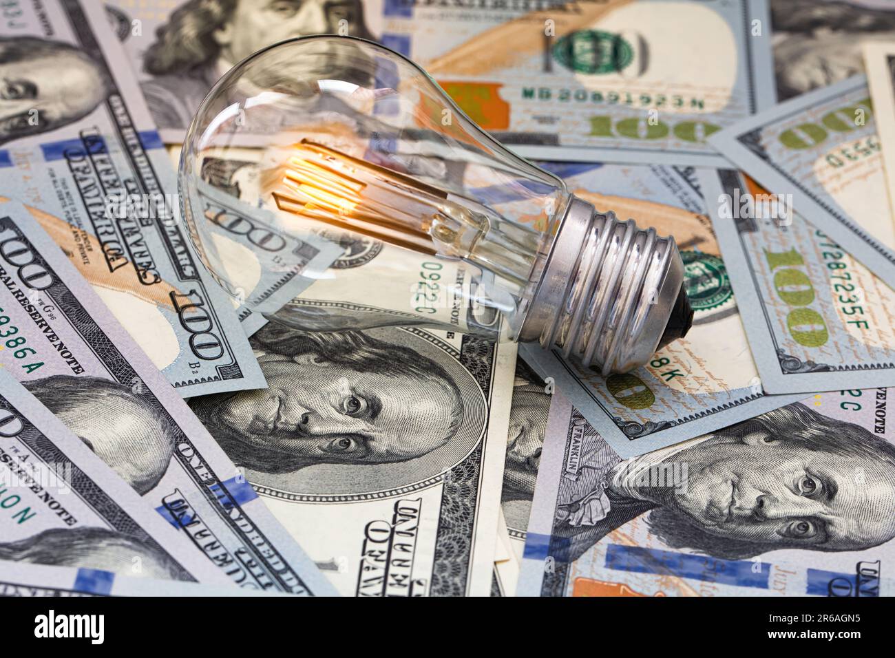 Incandescent light bulb on US 100 dollar background for desing purpose ...