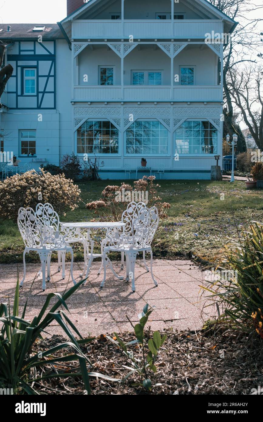 An outdoor seating area with two tables and chairs in the foreground ...