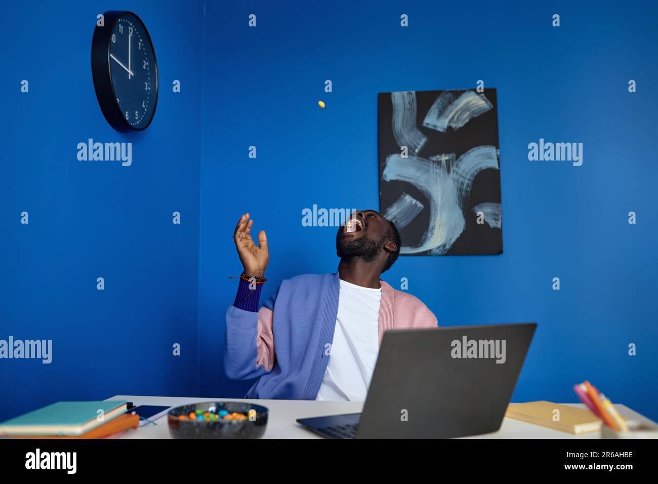 Portrait of creative black man having fun in colorful office interior ...