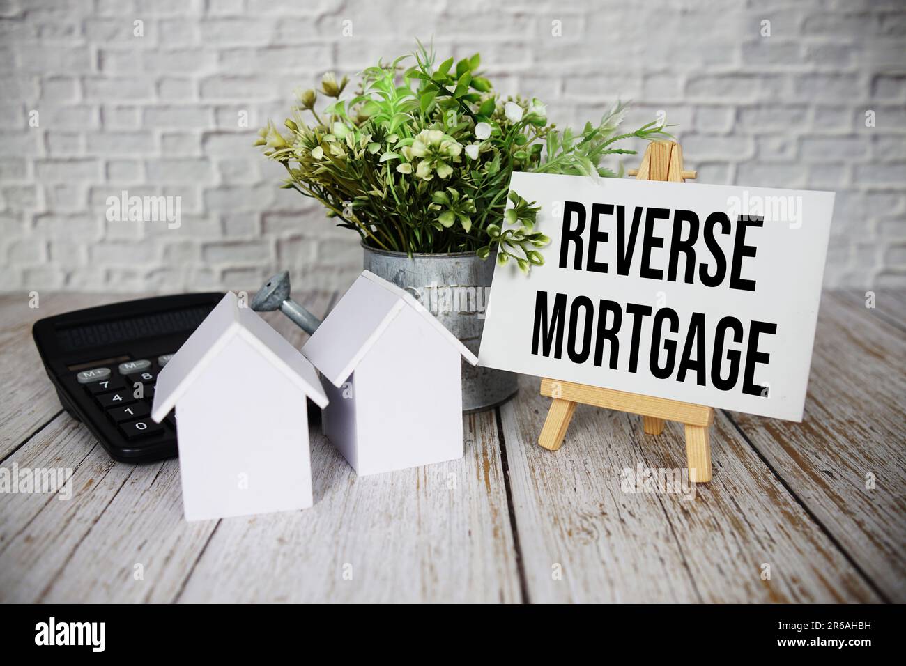 Reverse Mortage text message with house model and caculator on wooden ...