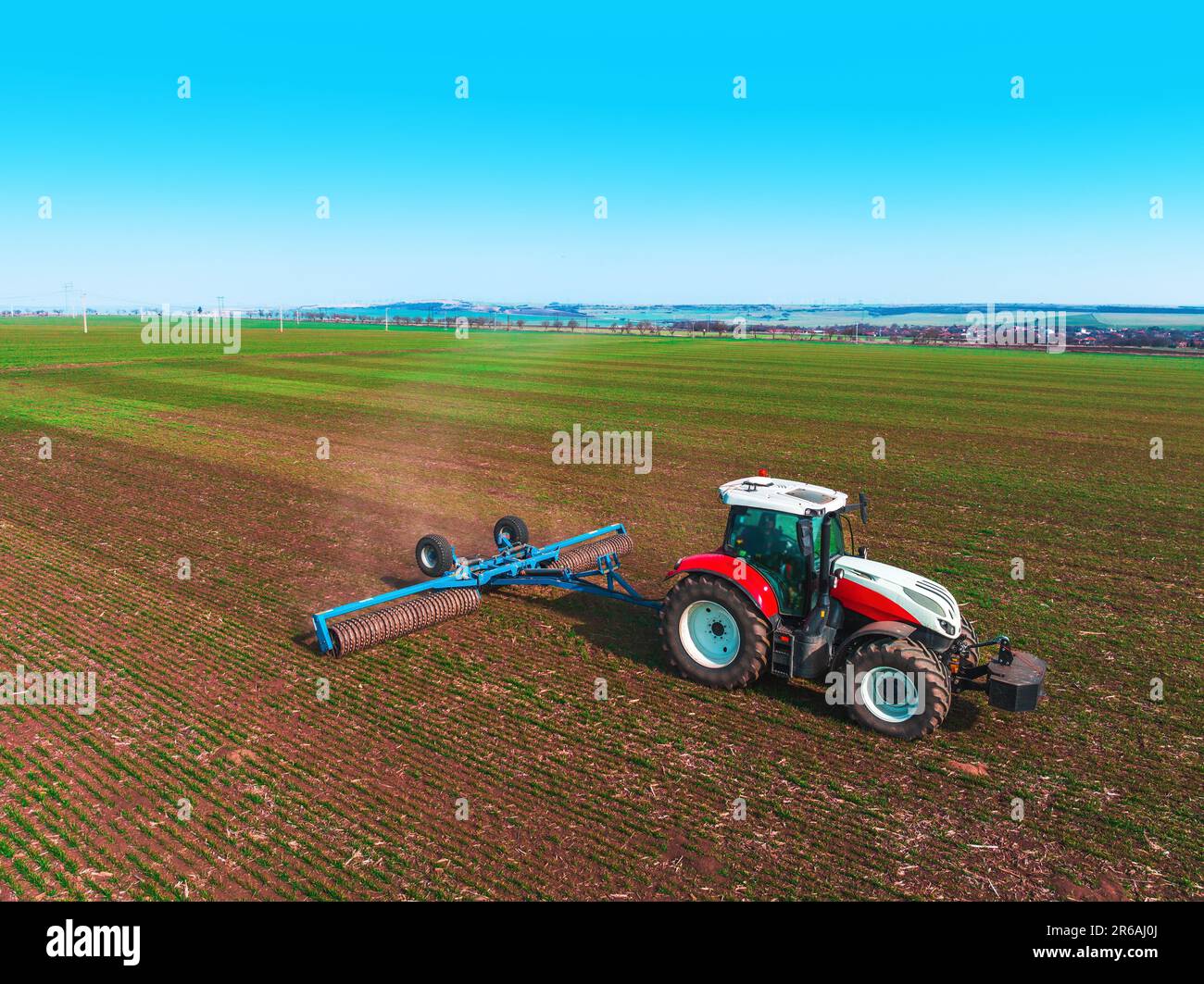 Tractor on agricultural field. Aerial view of Soil rolling agronomy ...