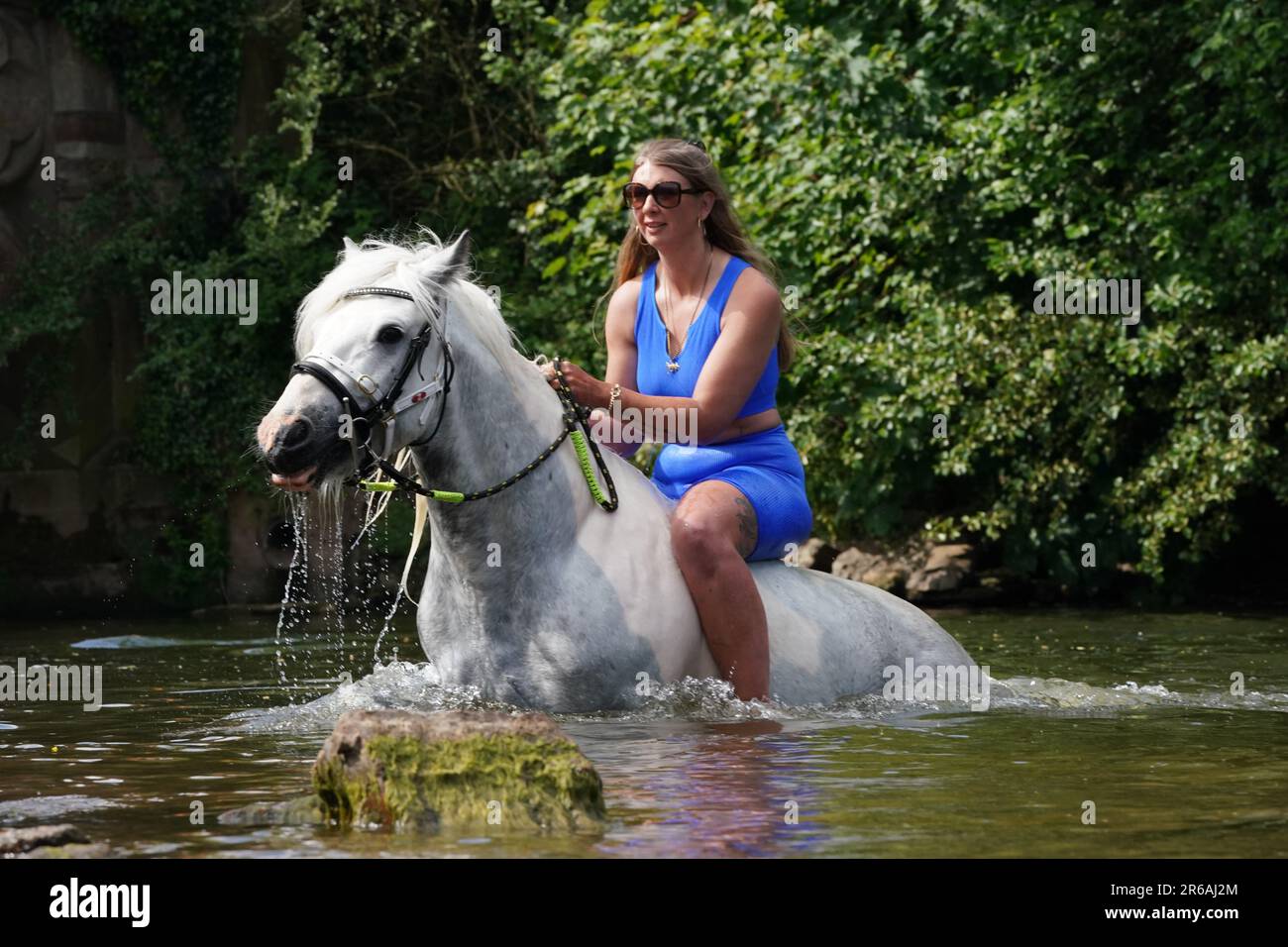 A women rides her horse through the river during the Appleby Horse Fair ...