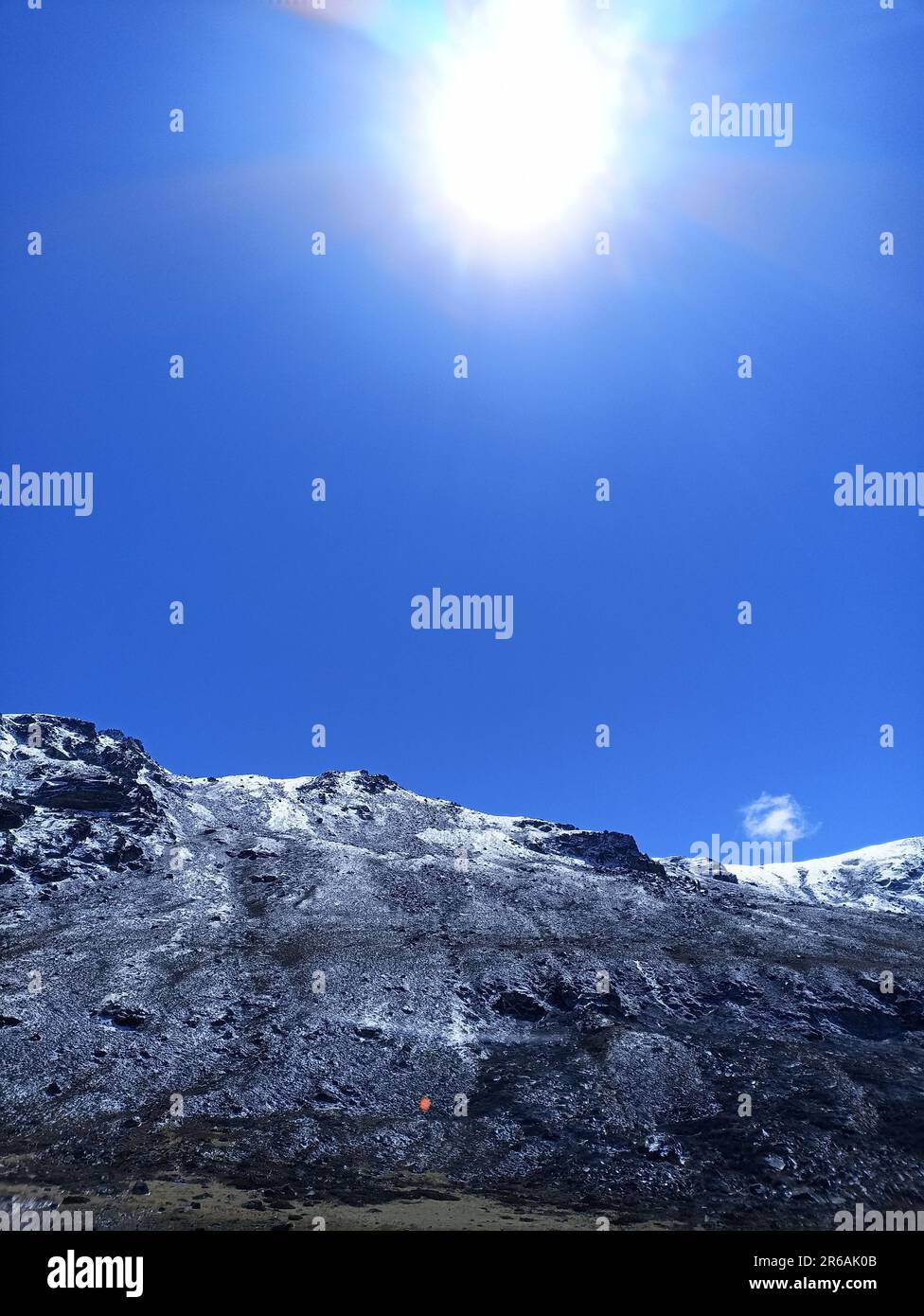 A picturesque landscape of a mountain peak with a single white dot ...