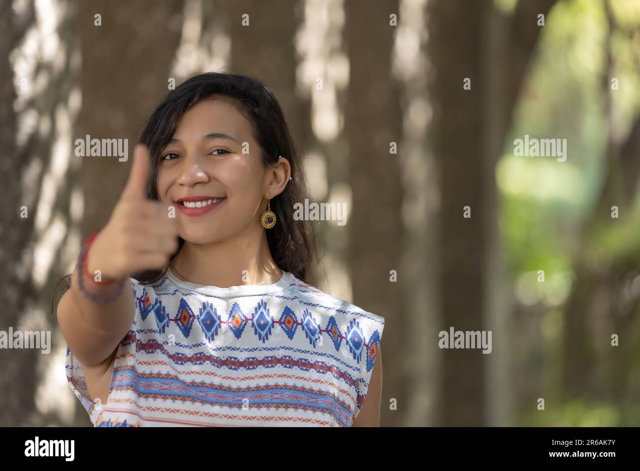 A female individual is happily smiling while raising their arm in the ...