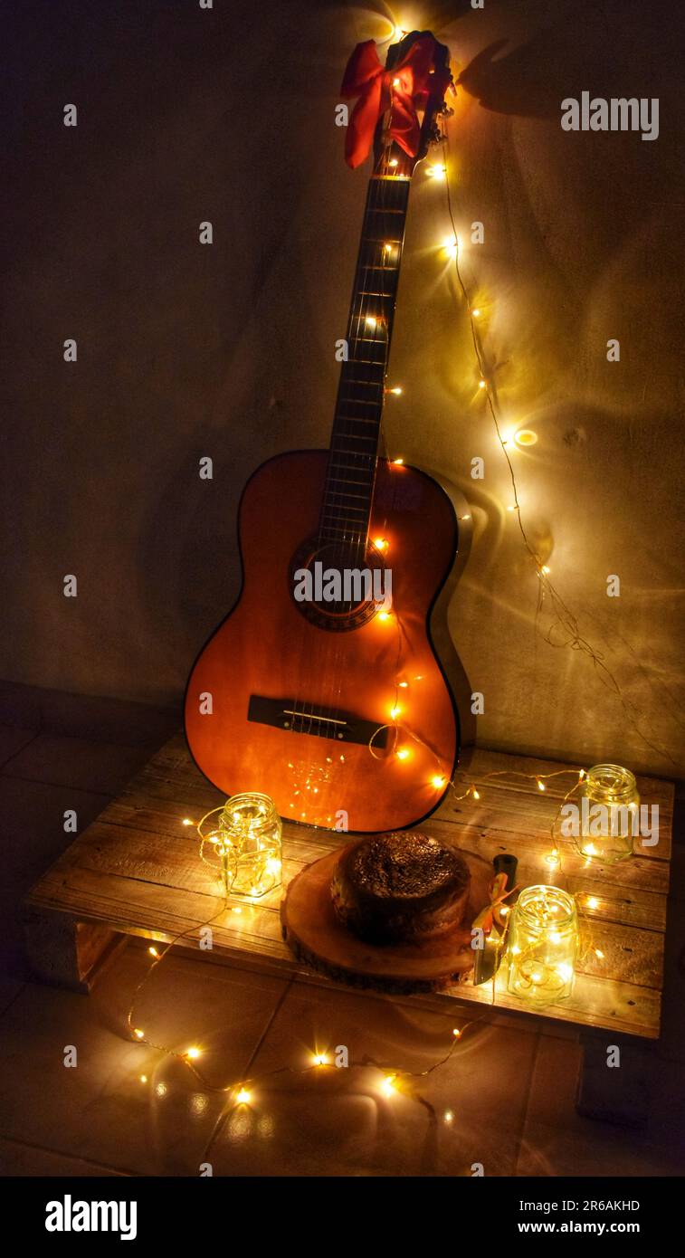 Vertical shot of a classical acoustic guitar lit up by a natural soft ...